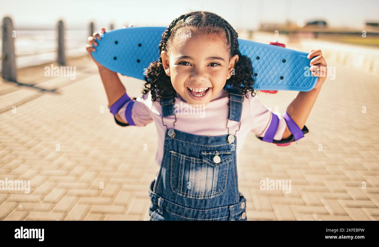 Child, skateboard and excited for fun activity outdoor on promenade ...