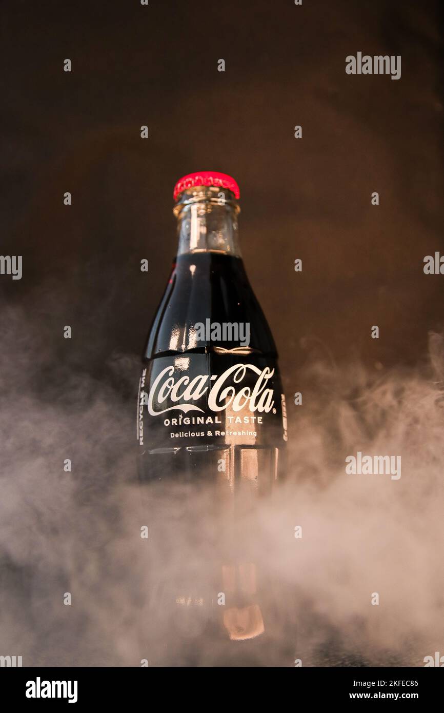 A coke bottle in smoke with a black background Stock Photo - Alamy