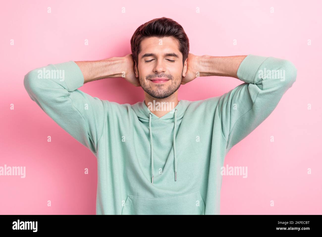 Photo of peaceful glad young man closed eyes arms behind head take nap ...