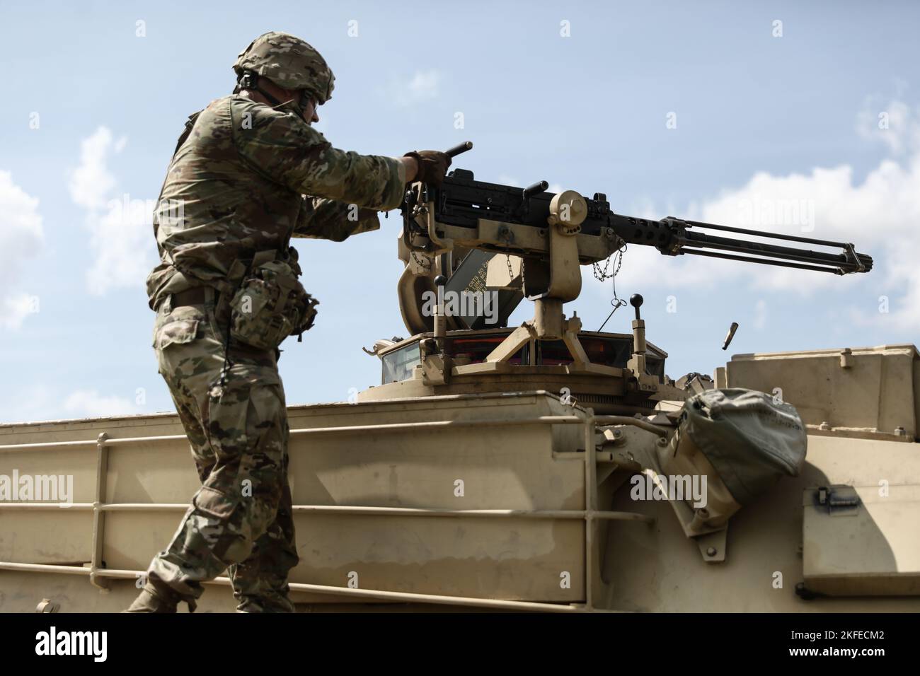 A Soldier prepares an M-2 .50 caliber machine gun at the range as he ...