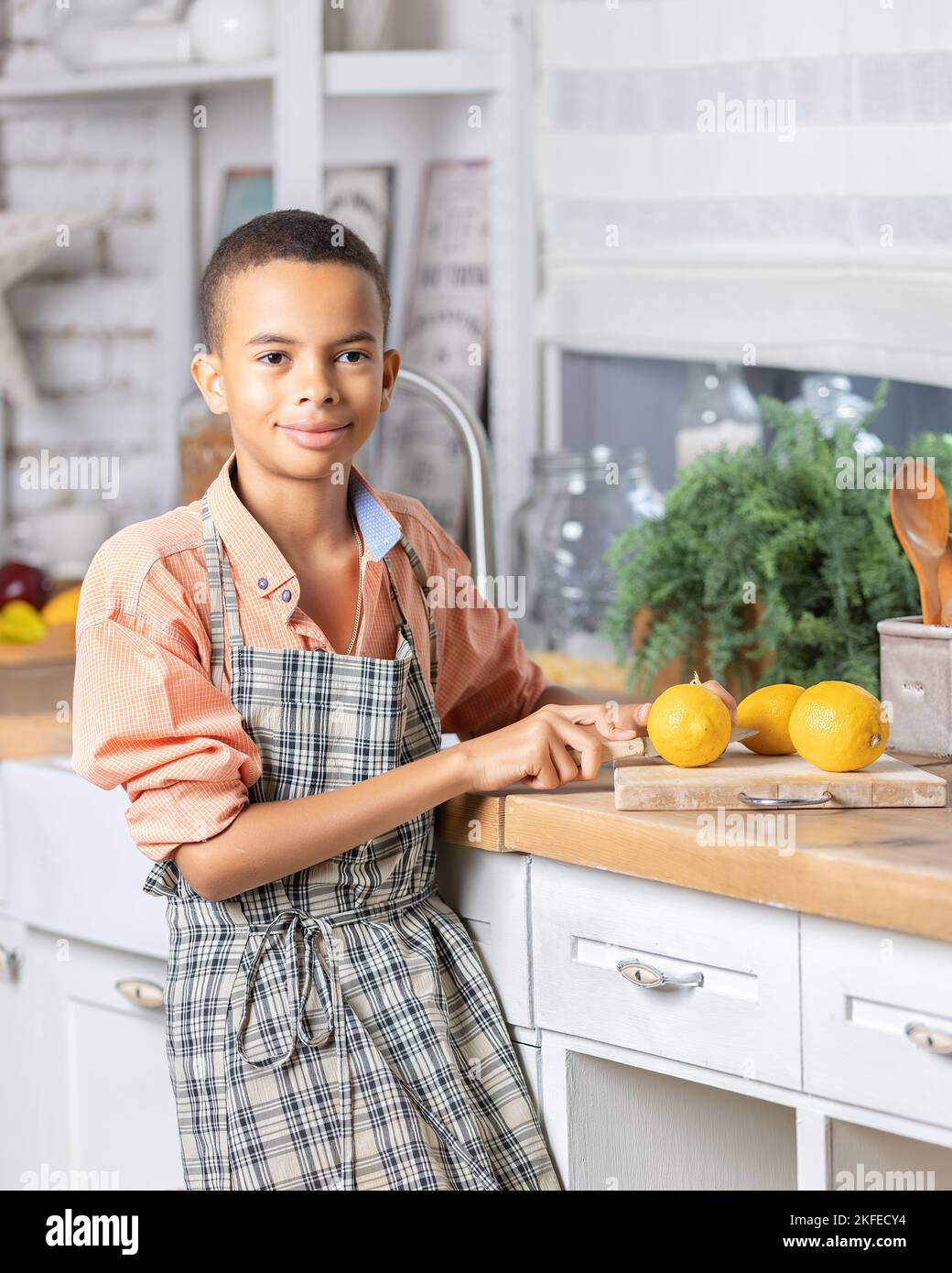 Black boy kid cooking fresh lemon on kitchen at home. African child ...