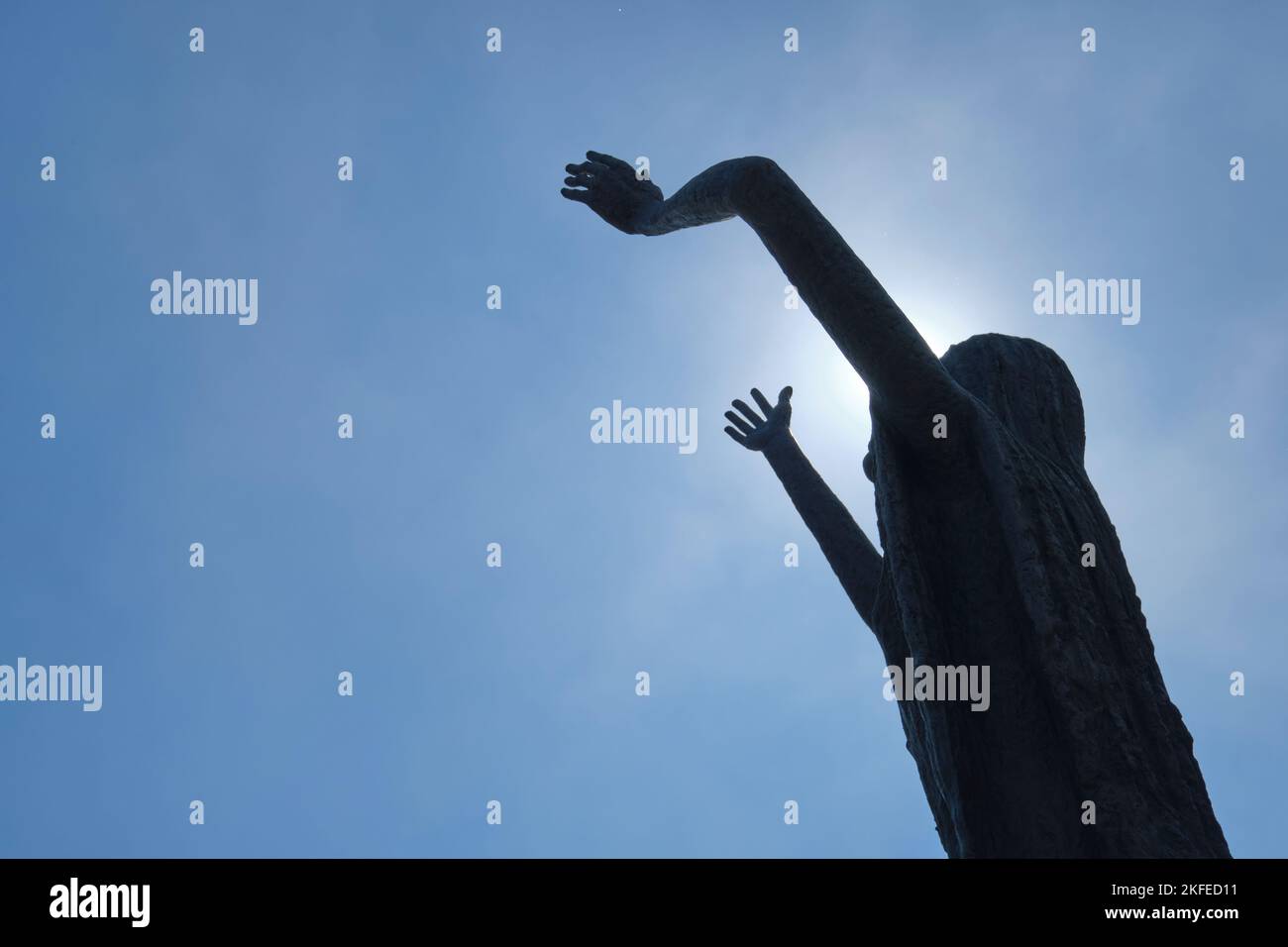 The statue silhouette of a starved person, upraised arms. At the ...