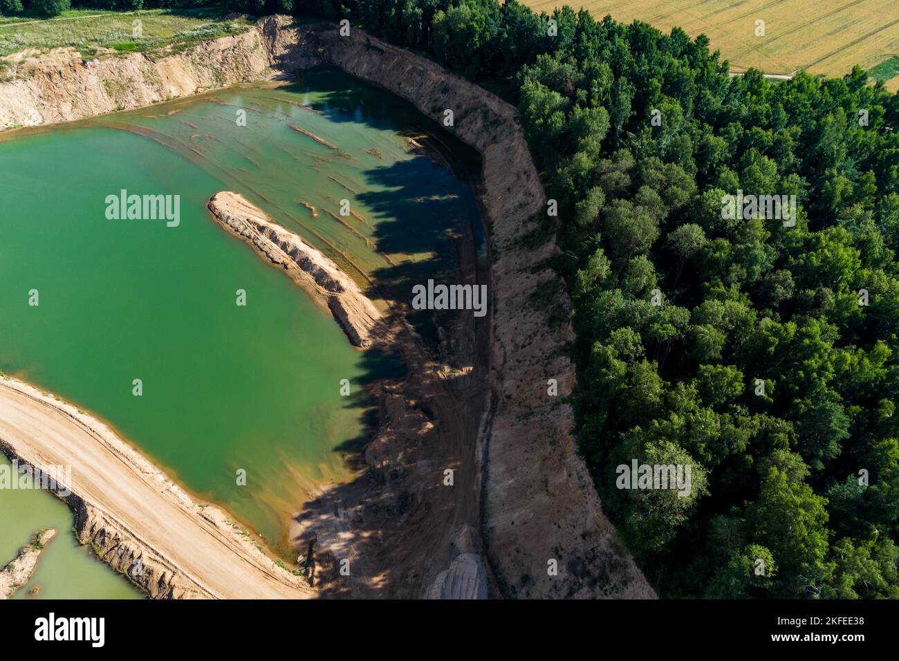 The flooded part of the sand pit on the border with the forest, aerial ...