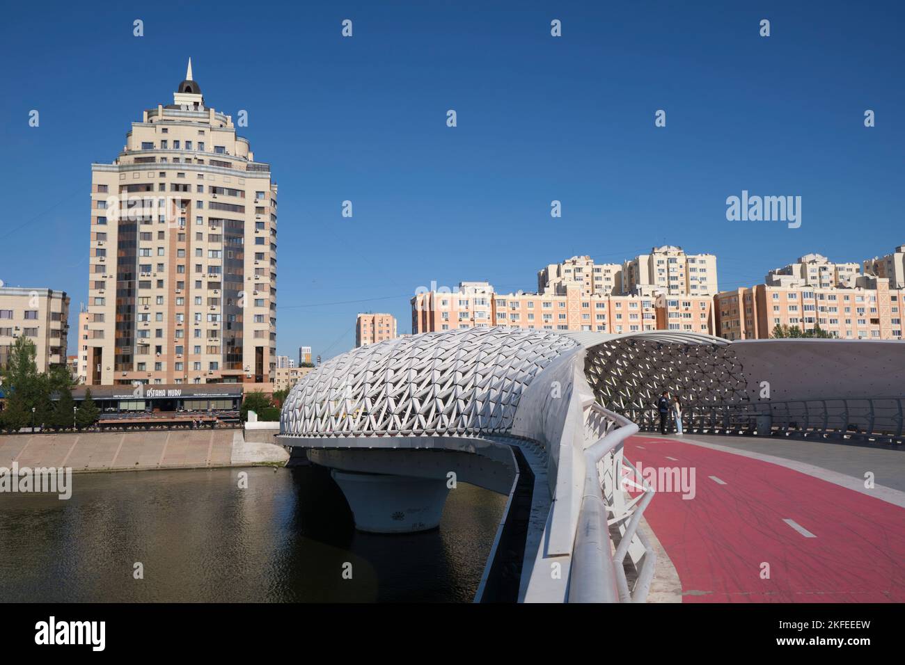 A view across the river, with red bike lane path.At the modern ...
