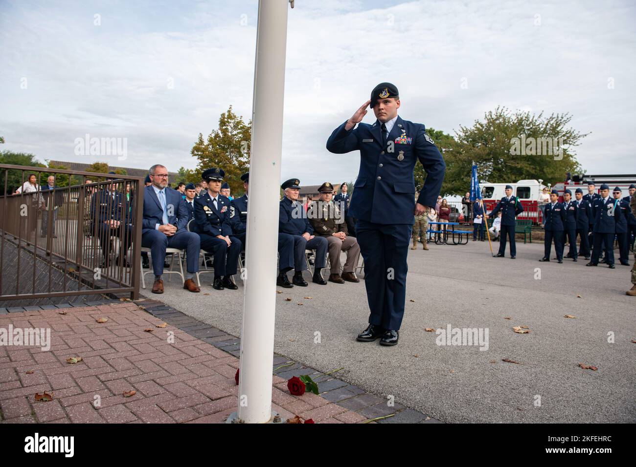 A 423d Security Forces Squadron member salutes after placing a rose at ...