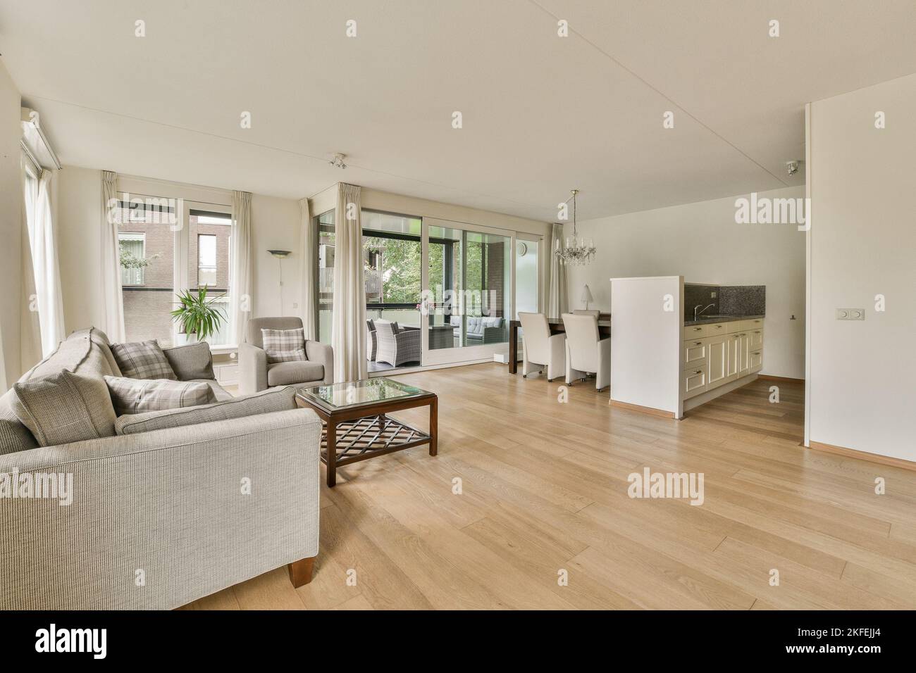 Table with chairs and flowers located near lounge area and kitchen in ...