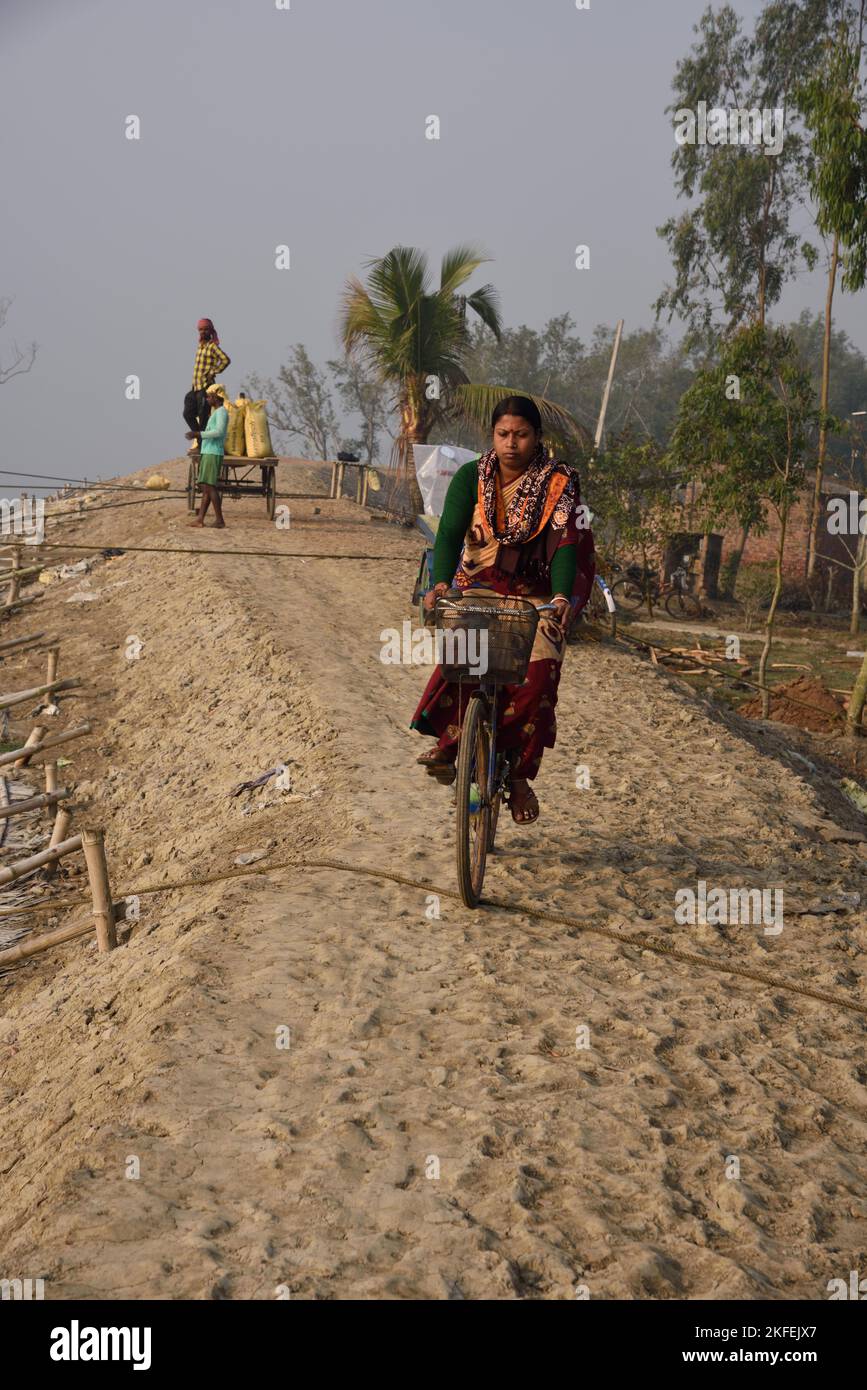Woman riding bicycle, Pakhiralay, Gosaba, Sunderban, South 24 Pargana ...