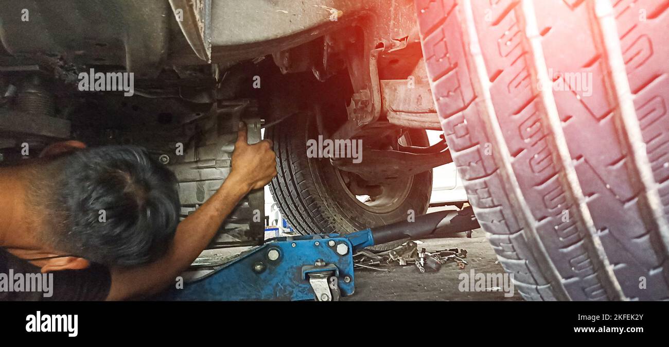 Car undercarriage and mechanic repairing undercarriage of the car Stock ...
