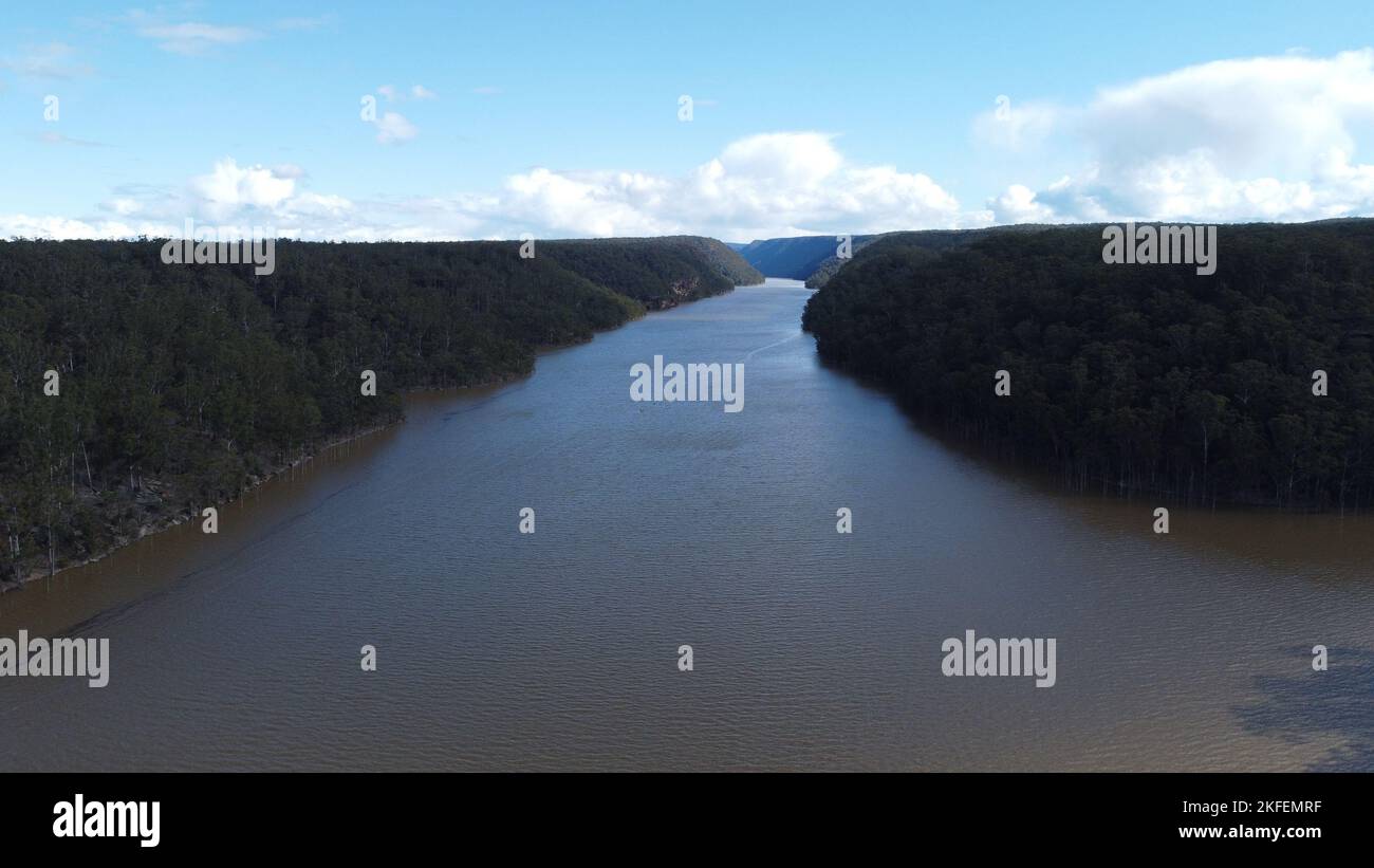 An aerial shot over a safari river surrounded by dense forests under ...