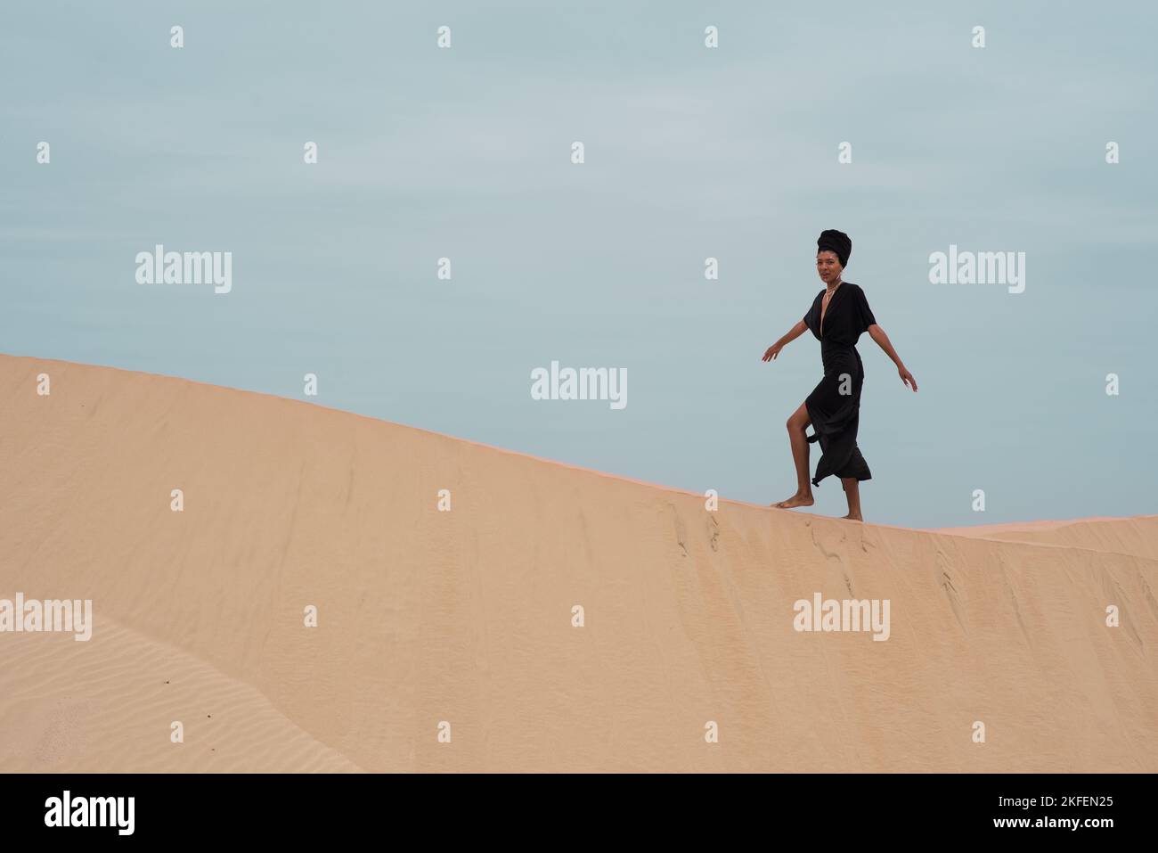 Single woman walking alone dune in nature Stock Photo - Alamy