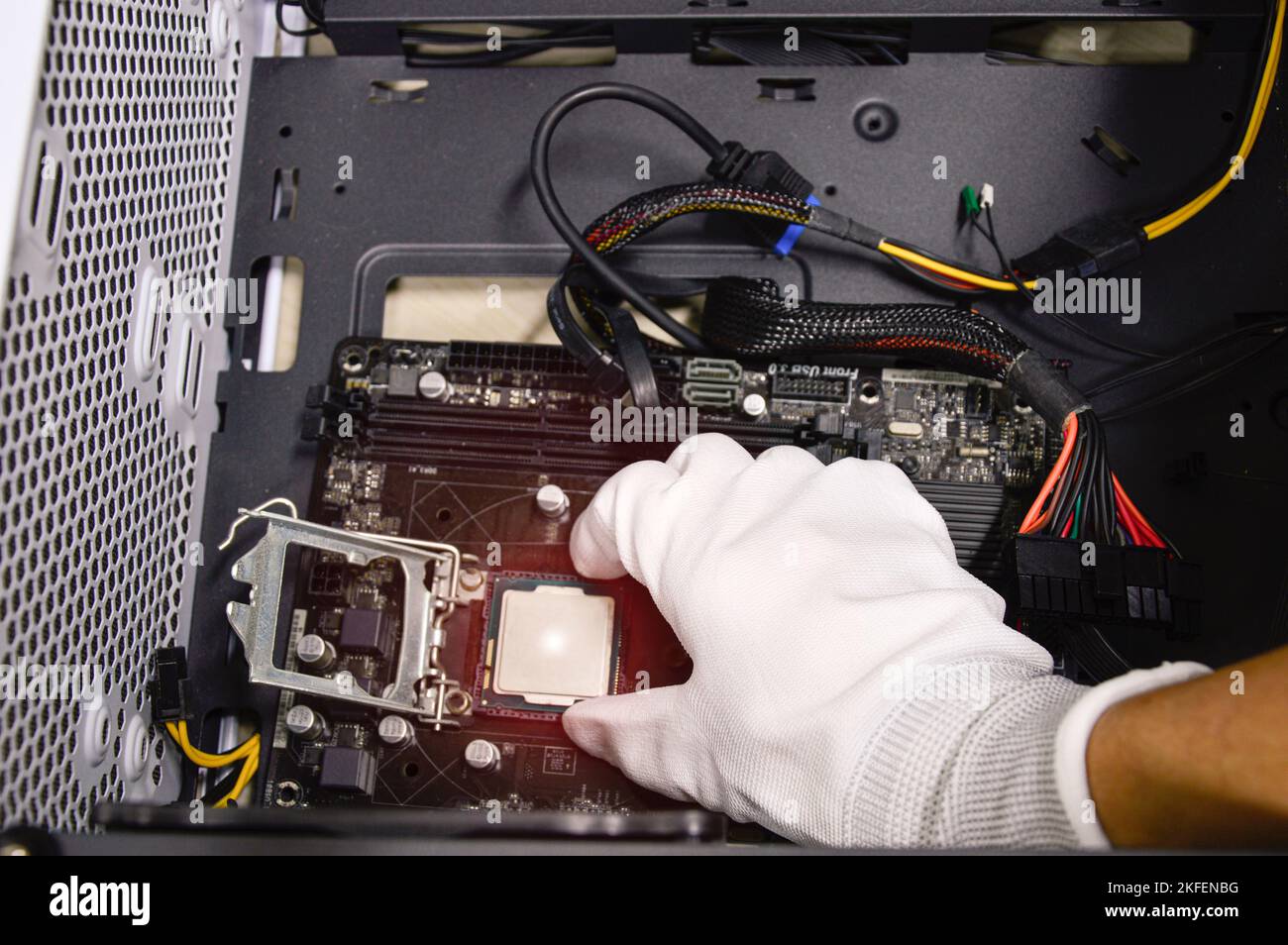 Image of a technician inserting a CPU chip onto a computer motherboard ...