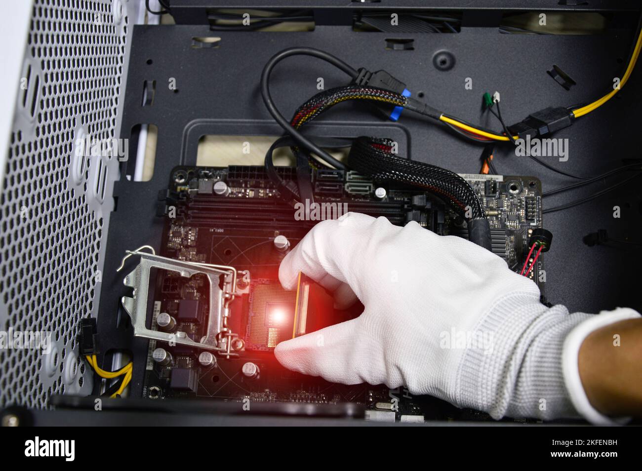 Image of a technician inserting a CPU chip onto a computer motherboard ...