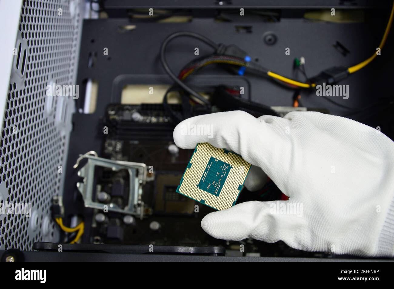 Image of a technician inserting a CPU chip onto a computer motherboard ...