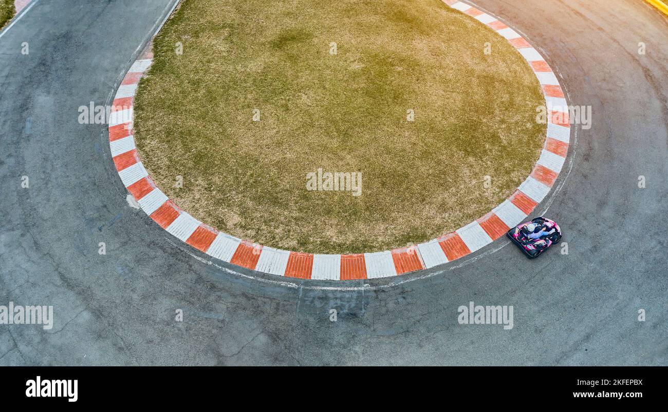 Aerial top view of the go-kart track from the drone. Kart racers drive ...