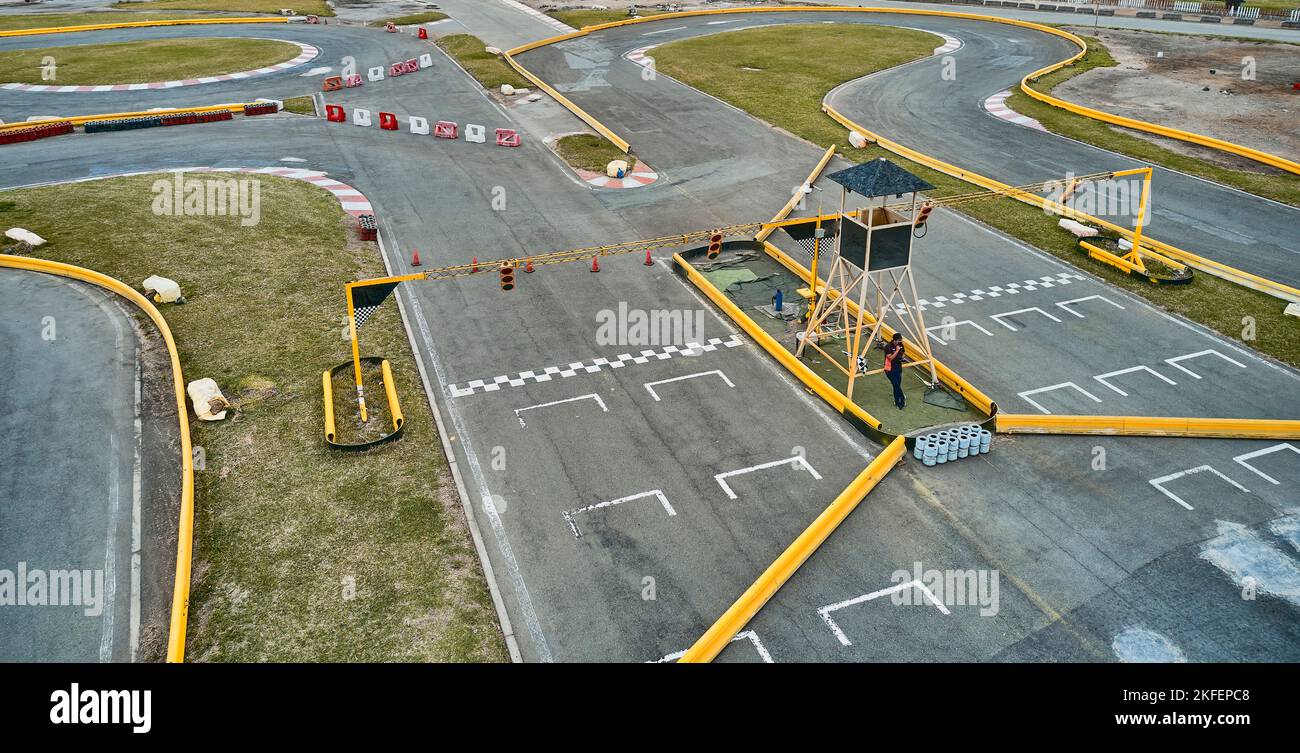 Aerial top view of the go-kart track from the drone. Kart racers drive ...