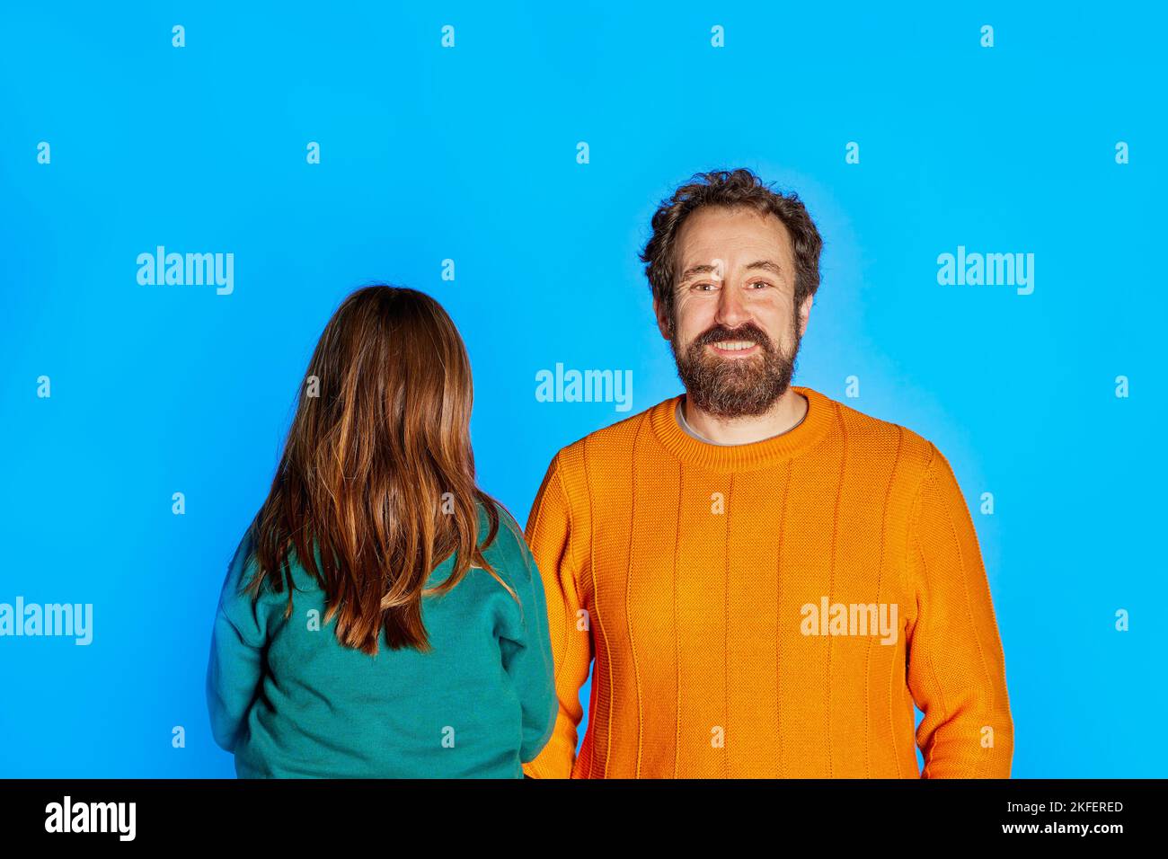 Funny dad with child daughter teen girl with isolated on blue ...