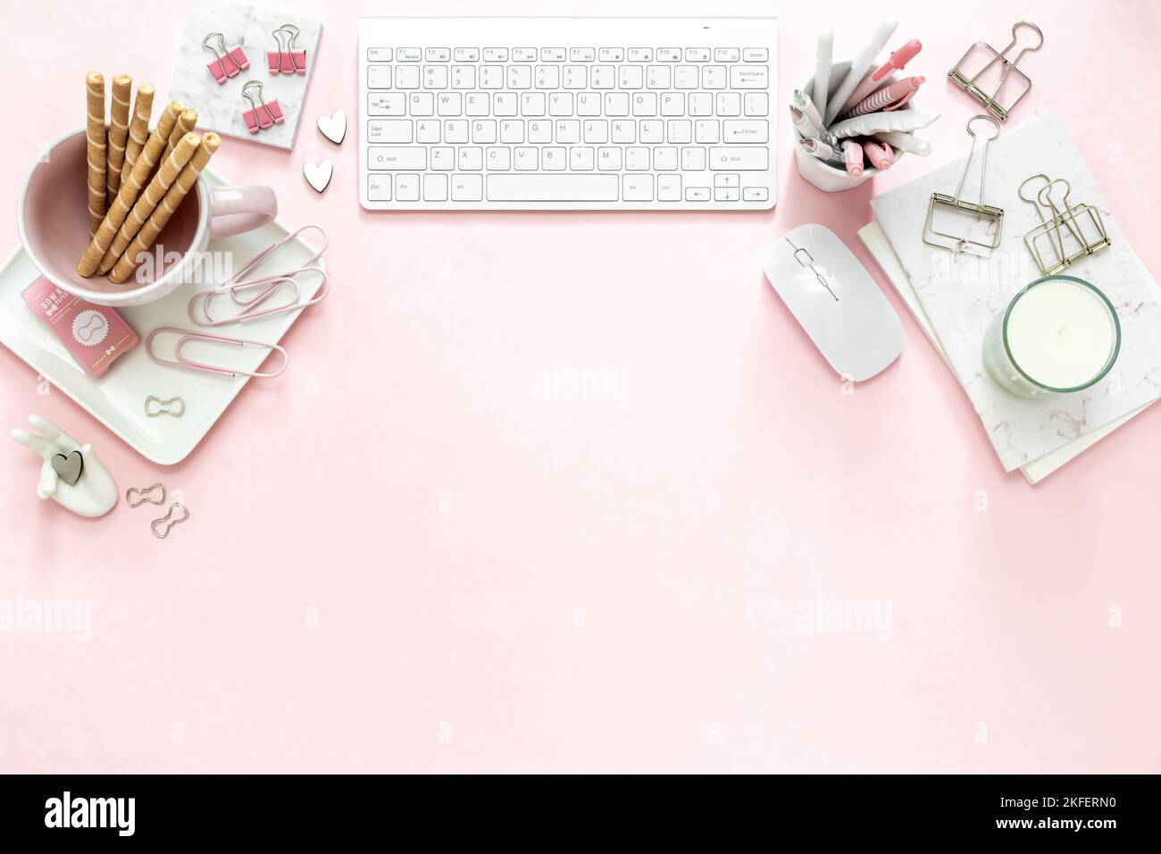 A feminine woman workspace, with a silver keyboard of a computer on a ...