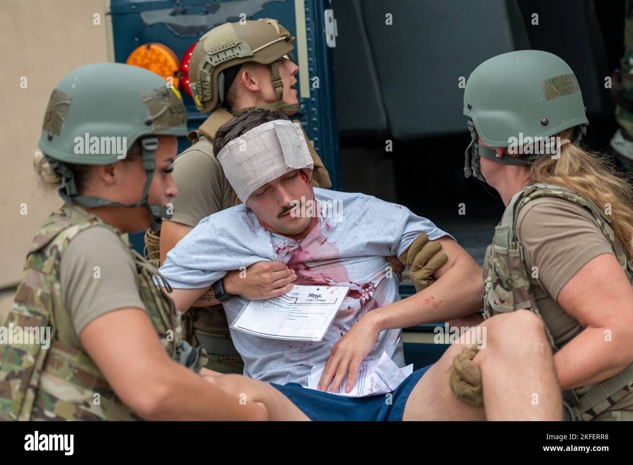 A simulated victim is lifted into the back of a transport vehicle by ...