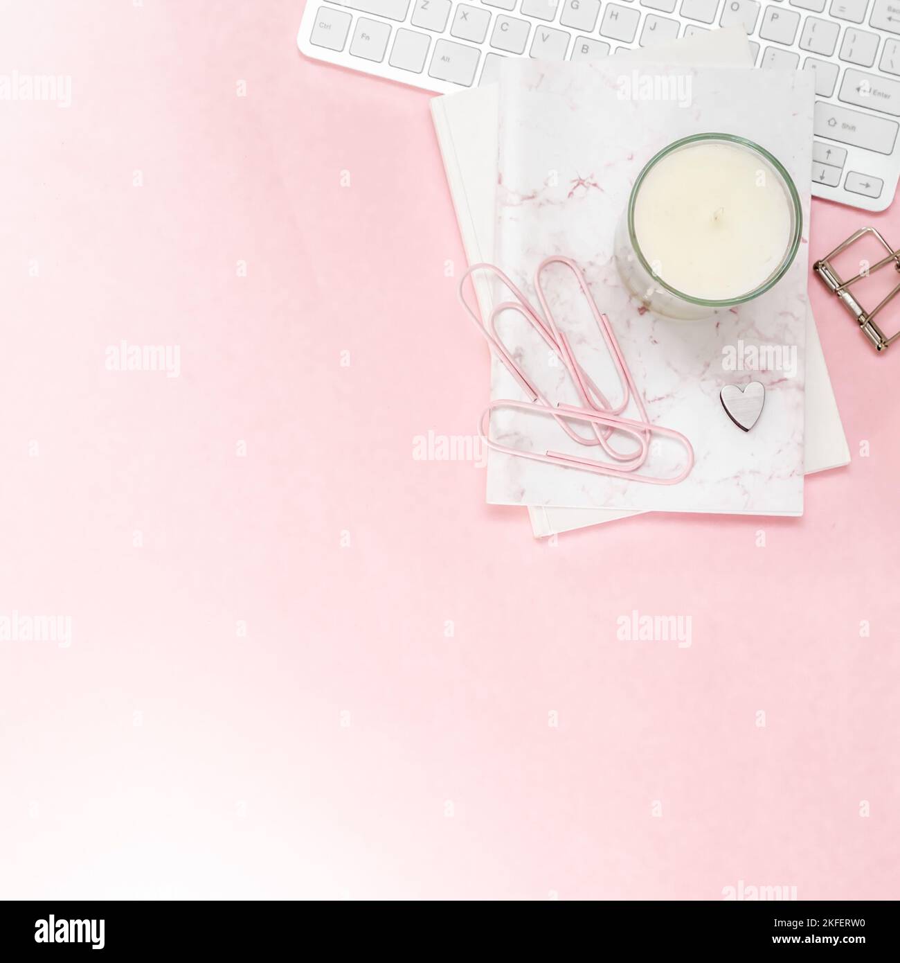 A feminine woman workspace, with a silver keyboard of a computer on a ...