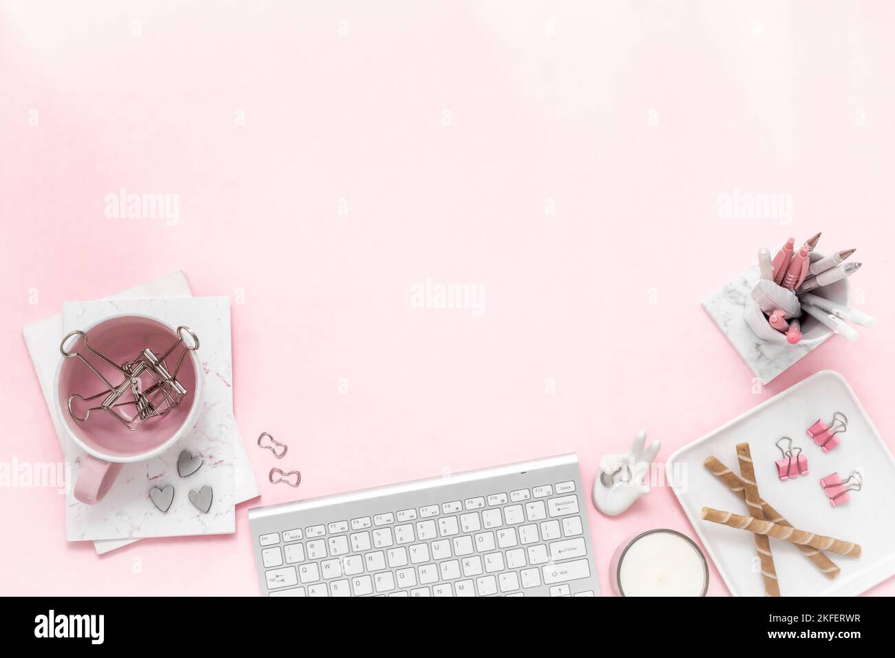 A feminine woman workspace, with a silver keyboard of a computer on a ...