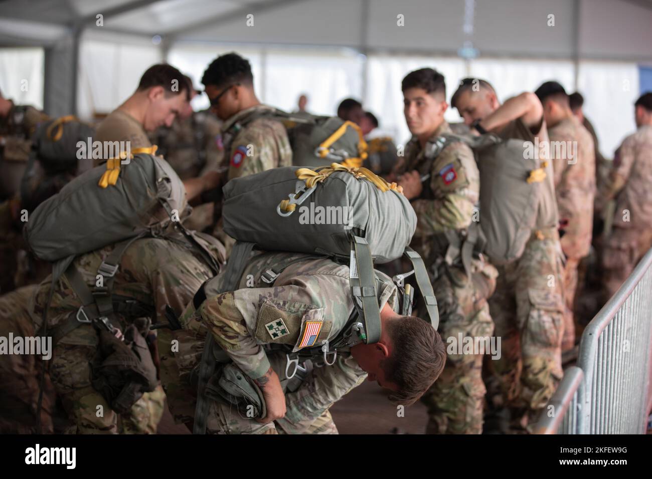 A group of U.S. Army Paratroopers help one another rig up into their T ...