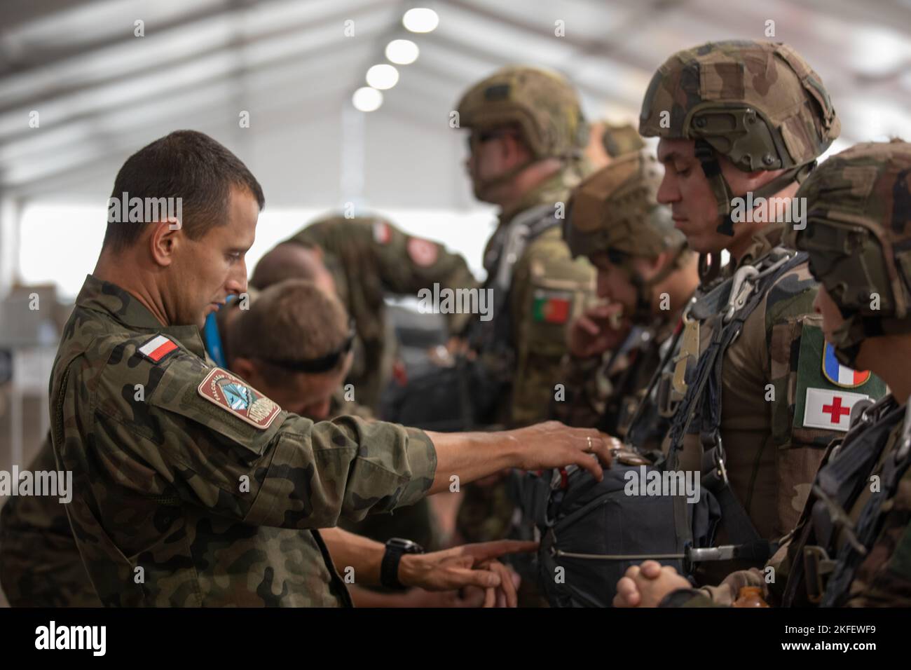 A Polish Jumpmaster conducts a Jumpmaster Personel Inspection (JMPI) on ...