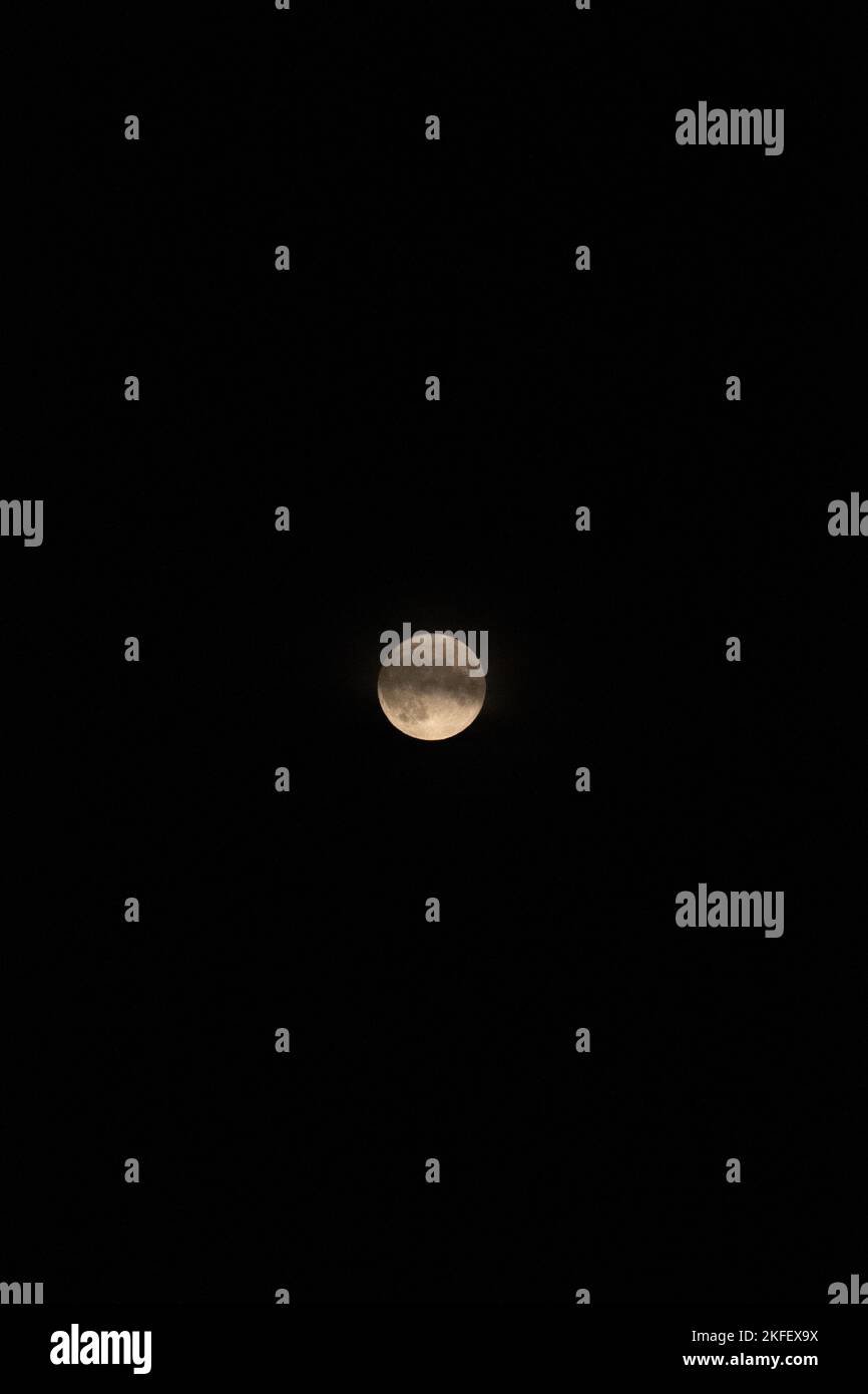 A vertical of a full moon lunar eclipse in the black sky Stock Photo ...