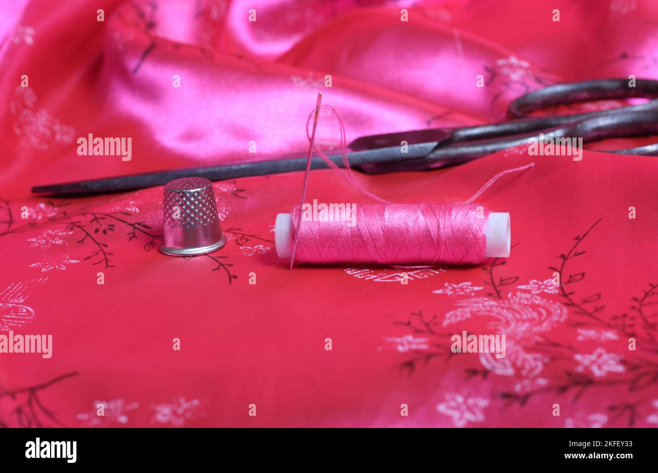 Spool of Pink Thread and Thimble on Vintage Pink Satin Stock Photo - Alamy