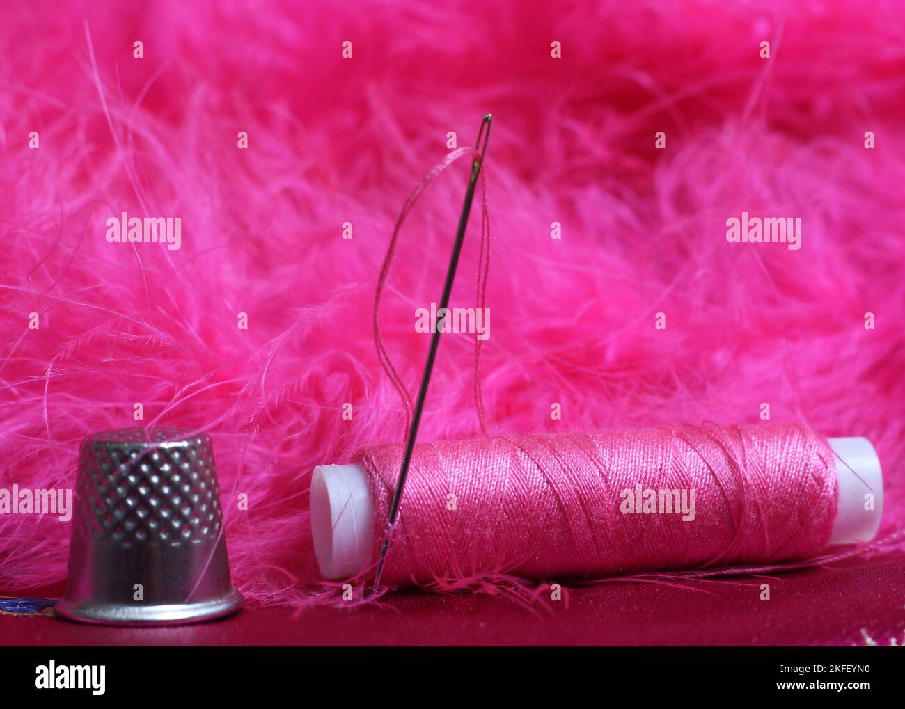 Spool of Pink Thread and Thimble on Vintage Pink Satin and Feather ...