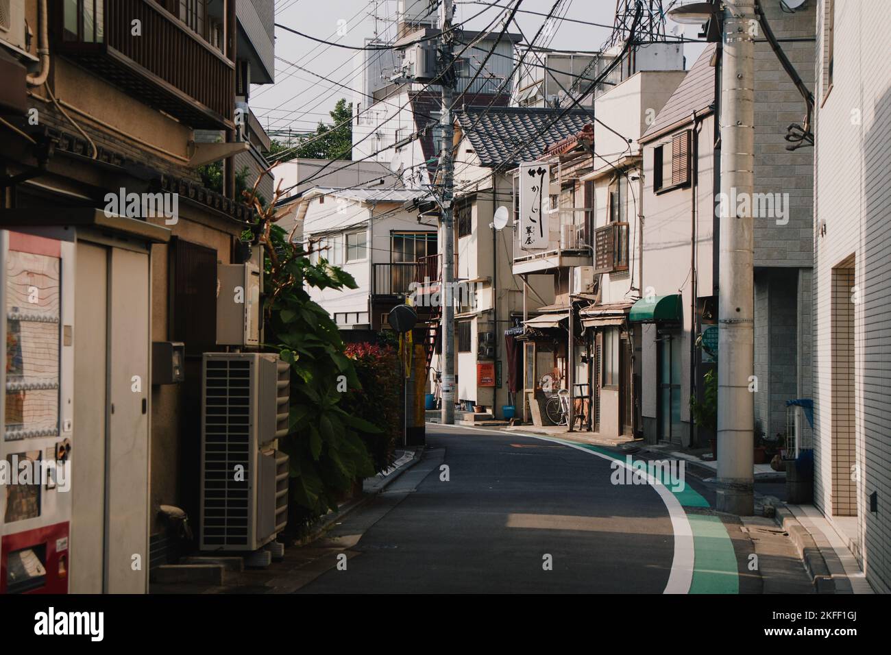 A horizontal image of a quiet Japanese street with buildings faceing ...