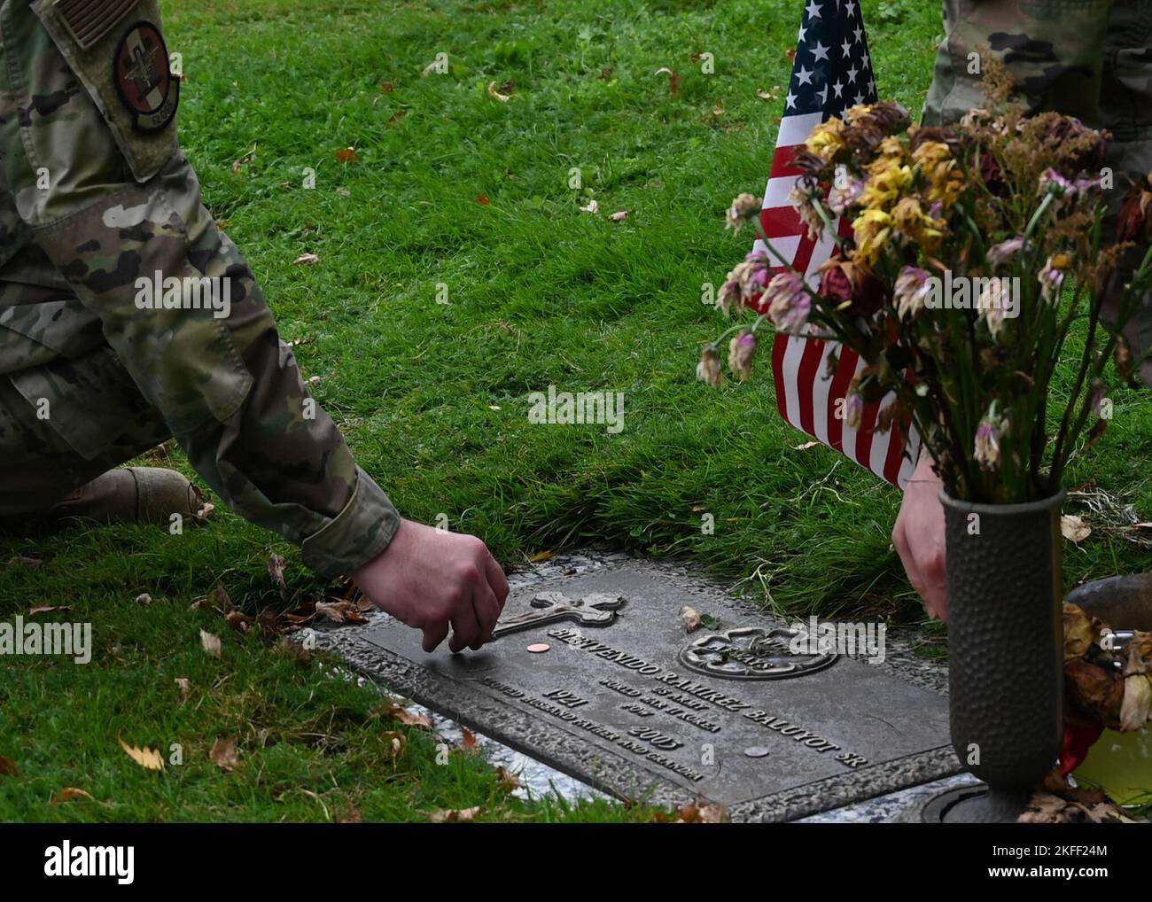 Team McChord Airmen place pennies on a prisoner of war’s grave as a ...