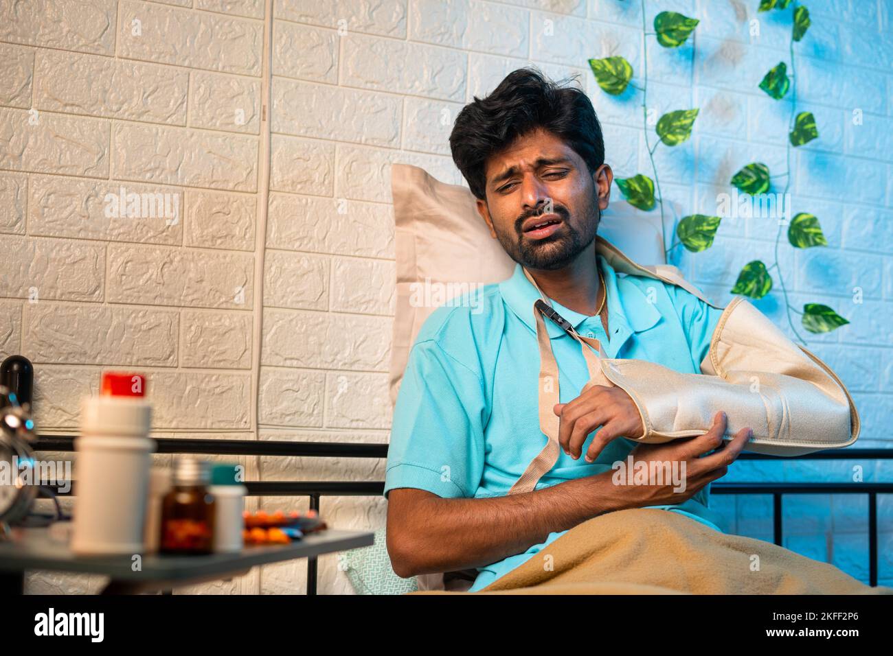 Young man suffering from broken hand at home - concept of medical or ...