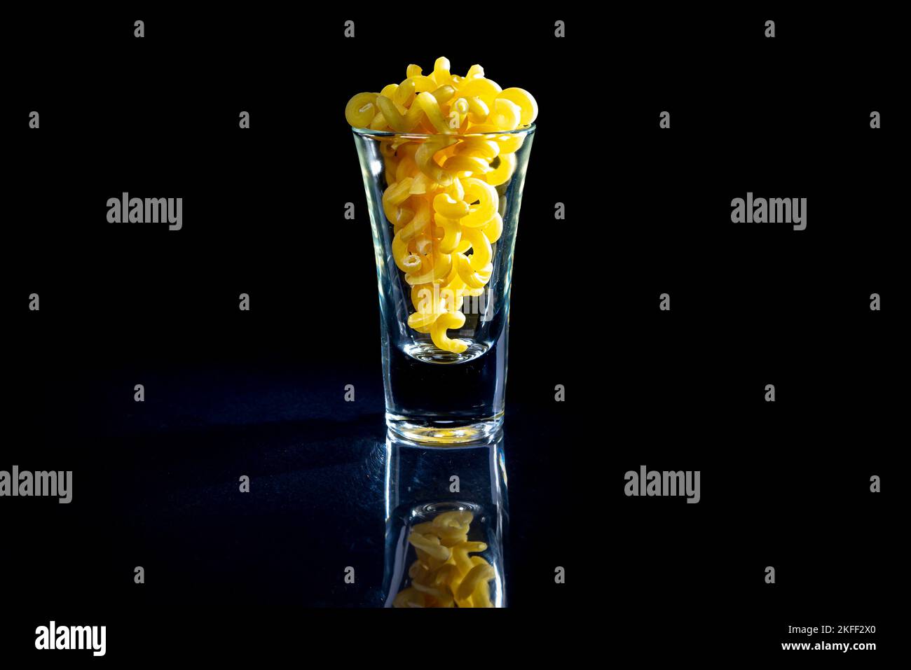 raw pasta in glass jar, wine glass. in bucket. raw pasta on black ...