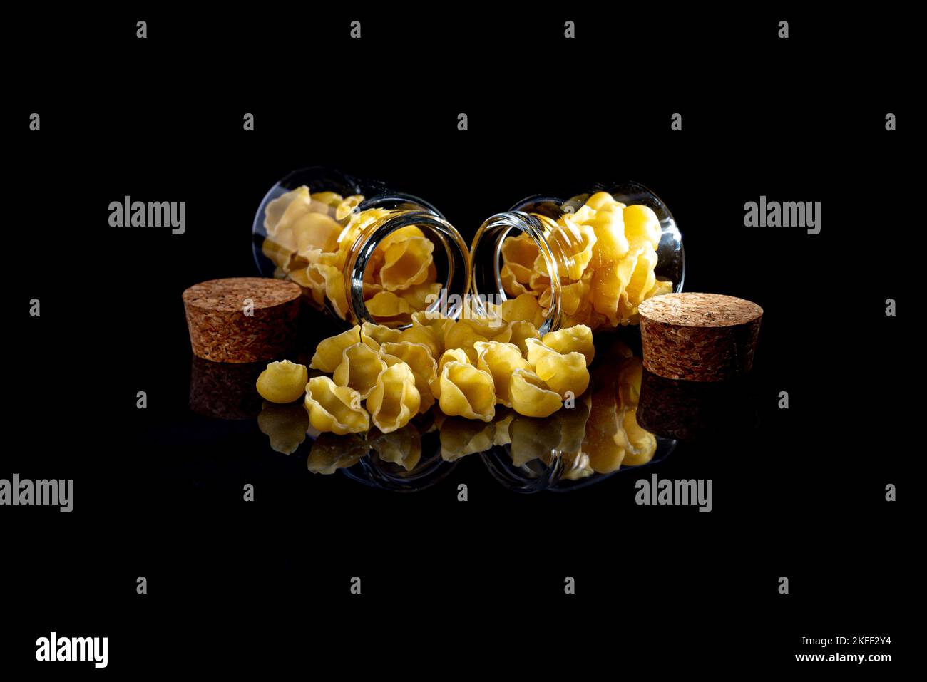 raw pasta in glass jar, wine glass. in bucket. raw pasta on black ...