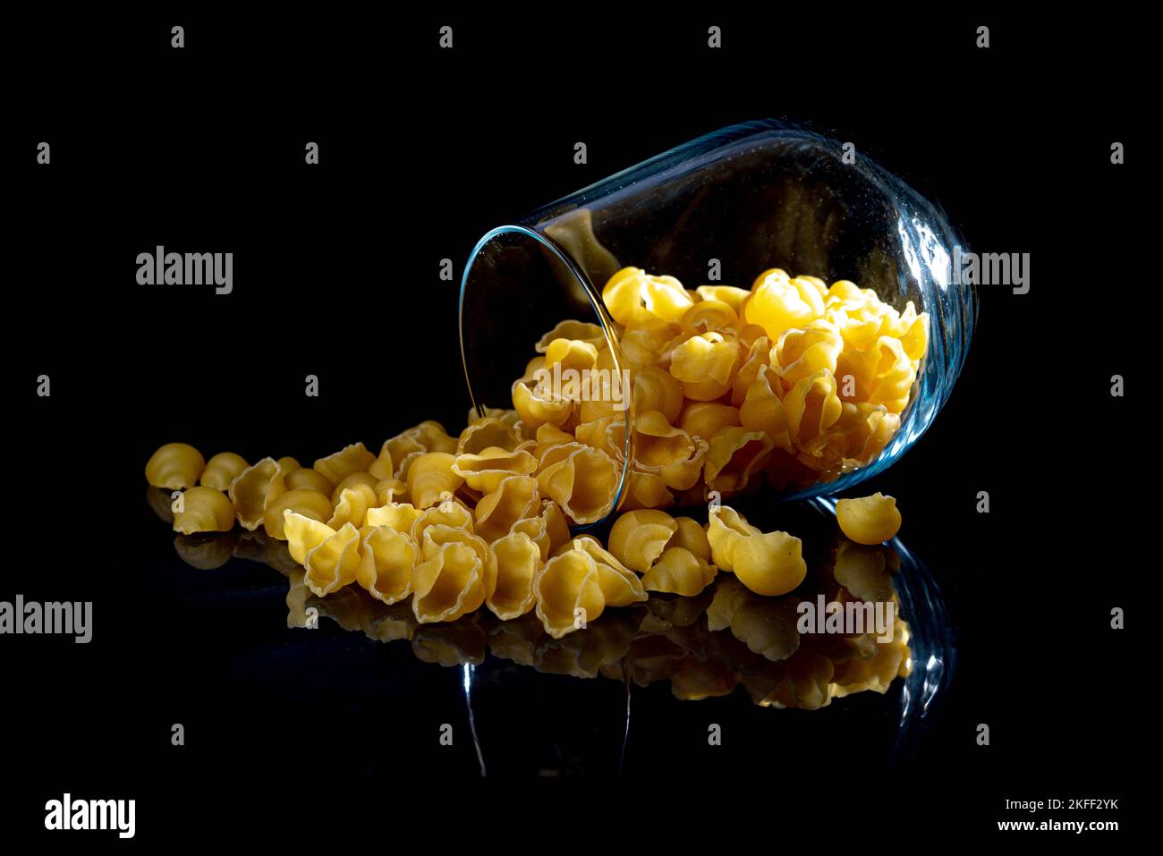 raw pasta in glass jar, wine glass. in bucket. raw pasta on black ...