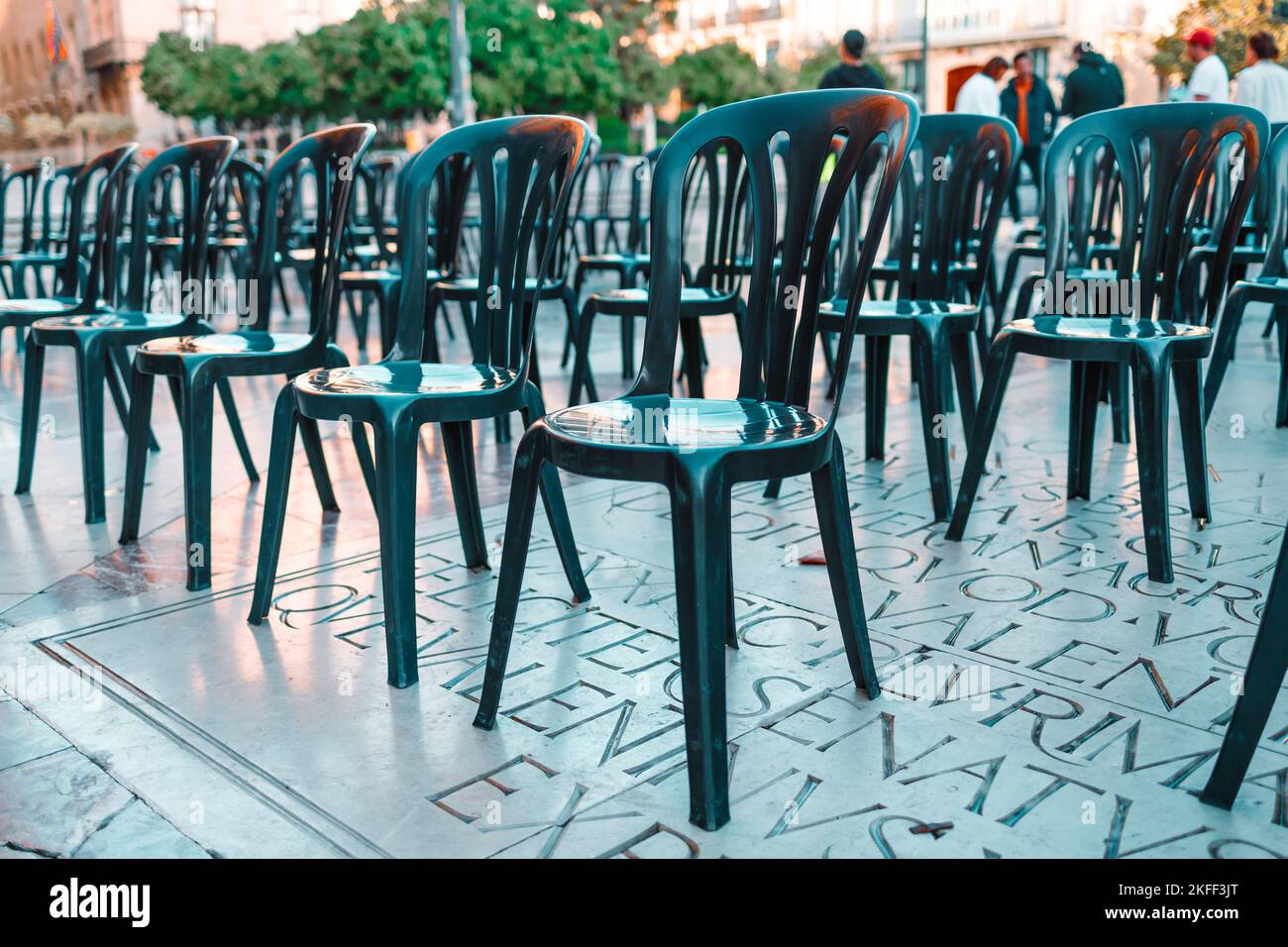 Black plastic chairs stand in rows. Black chairs with backs Stock Photo ...