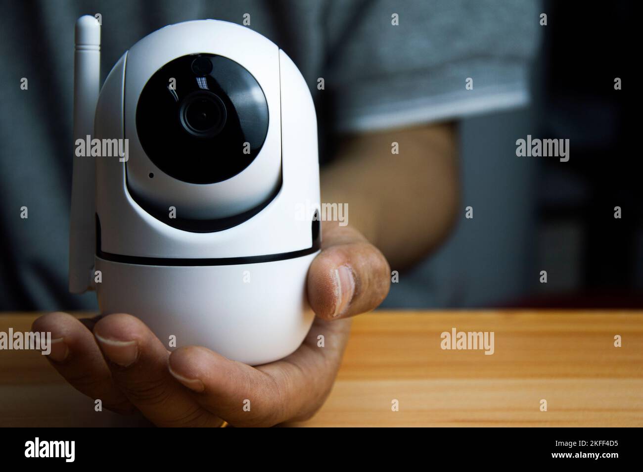 White ip camera lies on wooden floor, man using ip camera Stock Photo ...