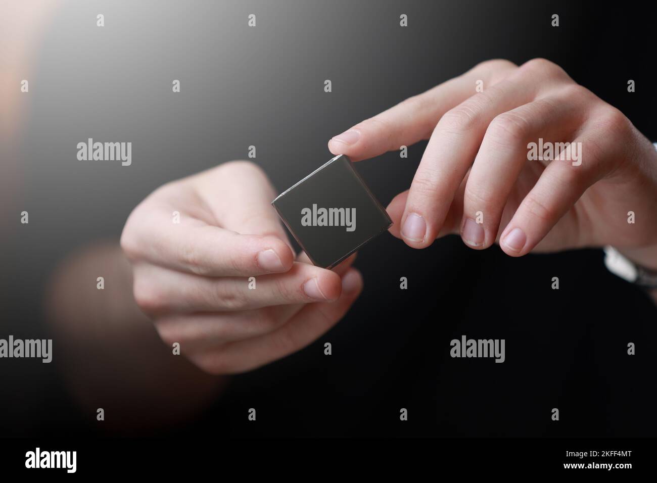Mans hands holding a square little black box with an copy empty space ...