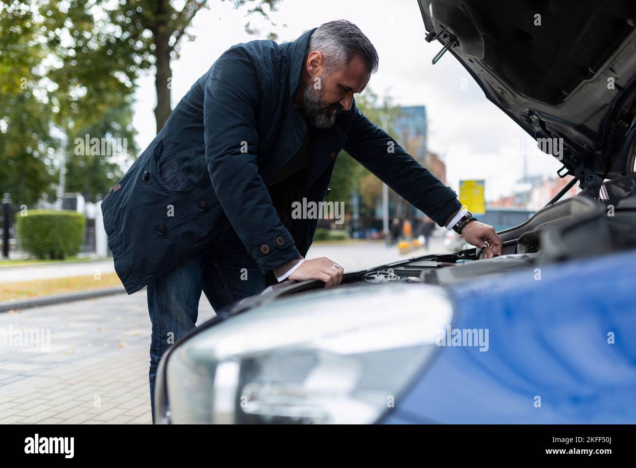 man fixing a broken car in the city Stock Photo - Alamy