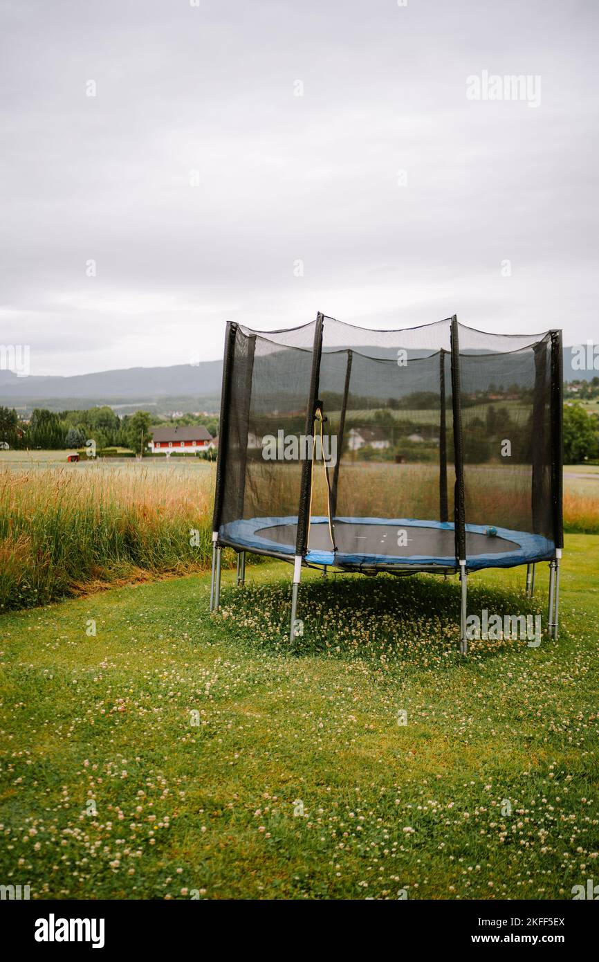 A vertical of a trampoline with a safety net under a cloudy sky Stock ...