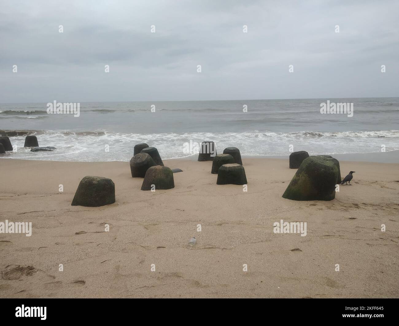 Stone on beach. Waves on beach. The stone dipped into sand. Sky touches ...