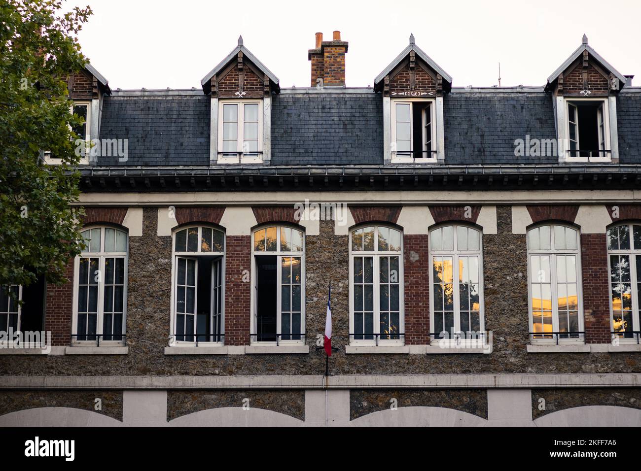 The view of a medieval fire station building with the French flag ...
