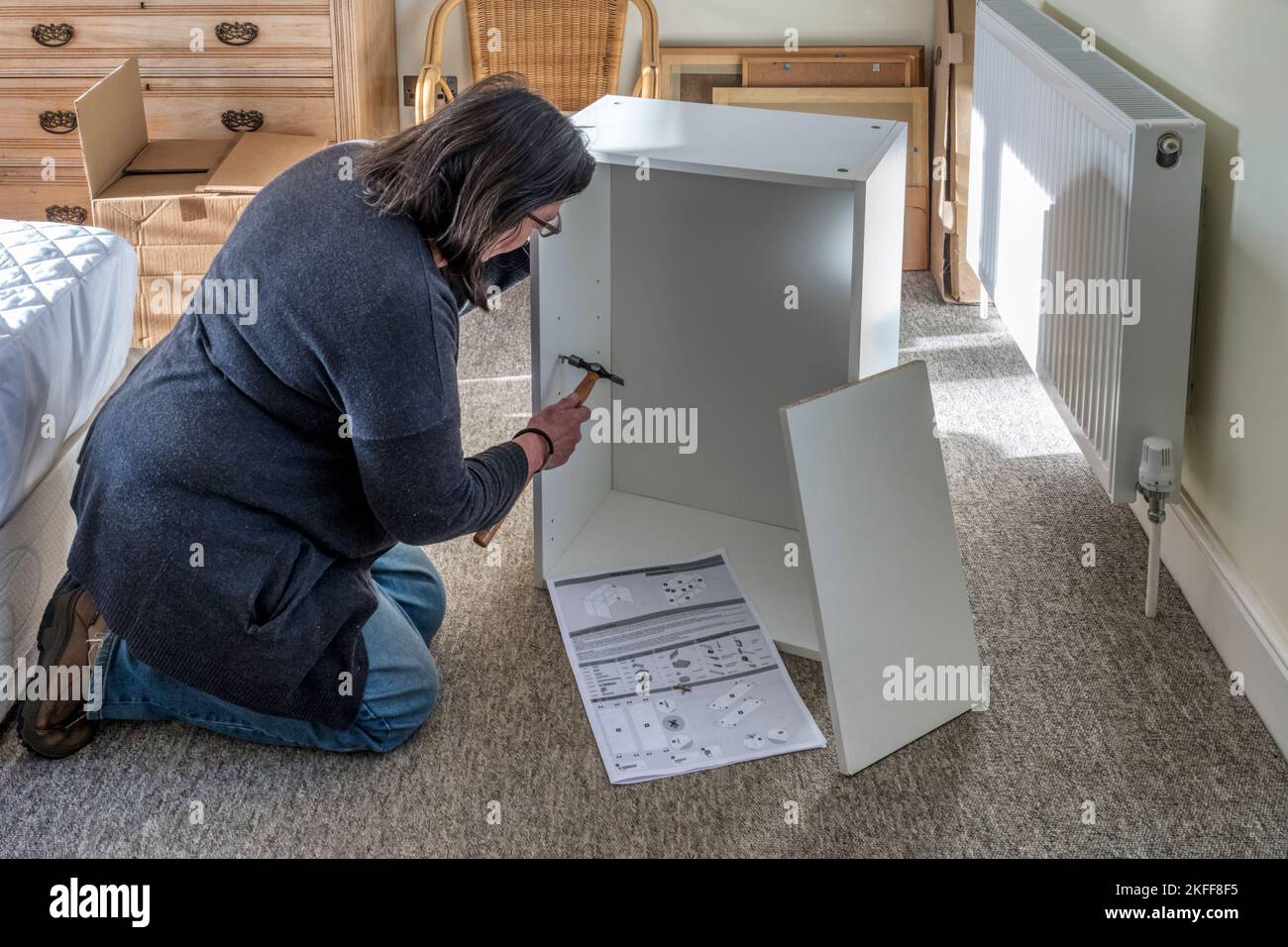 Woman building self-assembly furniture in a new house Stock Photo - Alamy