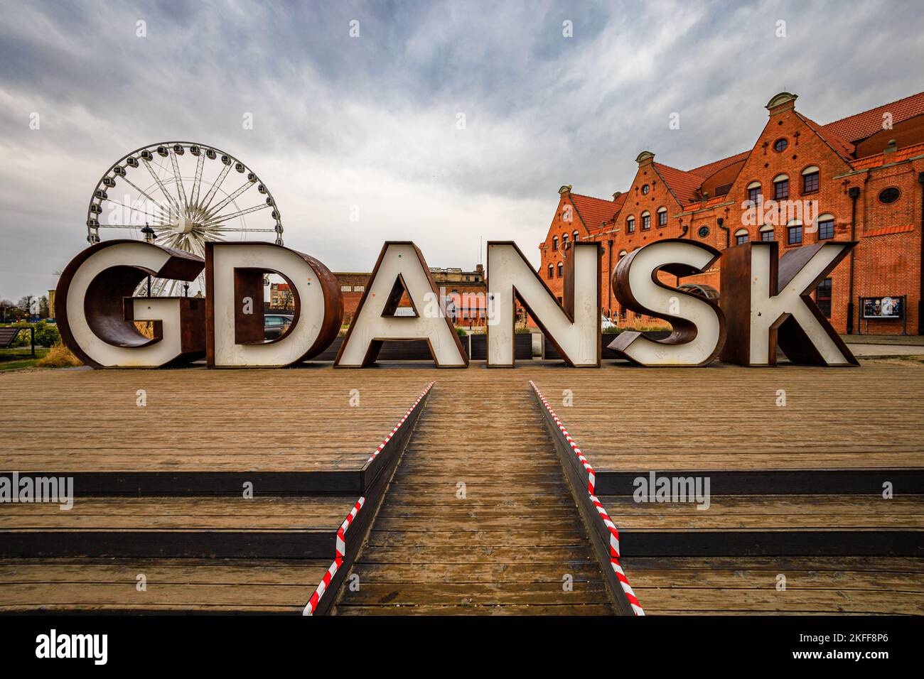 The city name with a Ferris wheel against the background of the cloudy ...