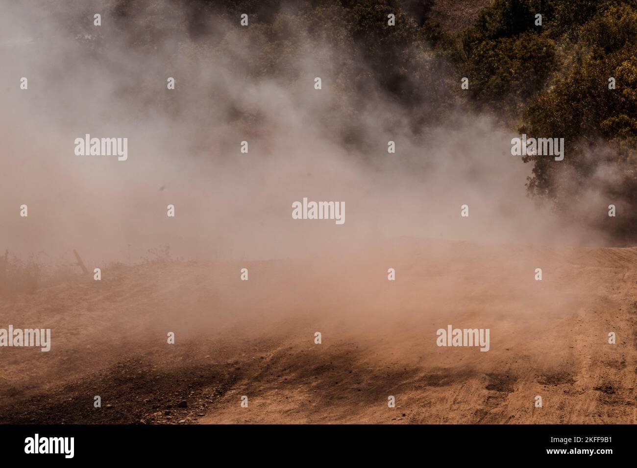 A dust storm. Powdered dust and sand flowing into air on a gravel road ...