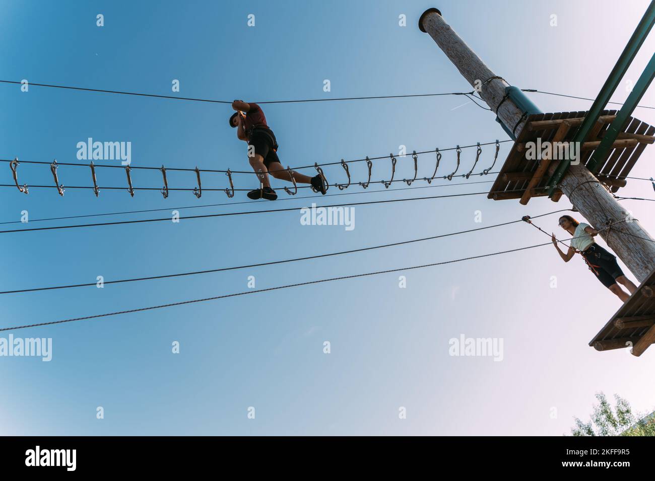 Strong boy climbing up in the air at the avdenture park Stock Photo - Alamy
