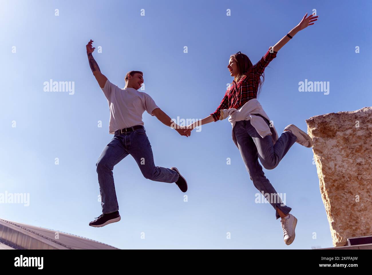 Cute couple jumping in the park while holding hands Stock Photo - Alamy