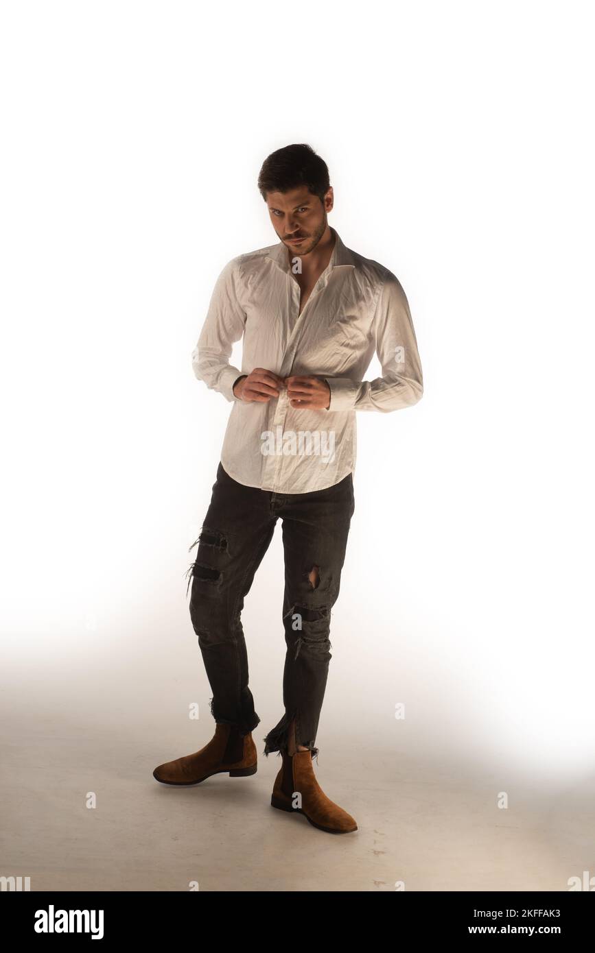 Handsome man undoing his shirt in a photoshoot in the studio Stock ...