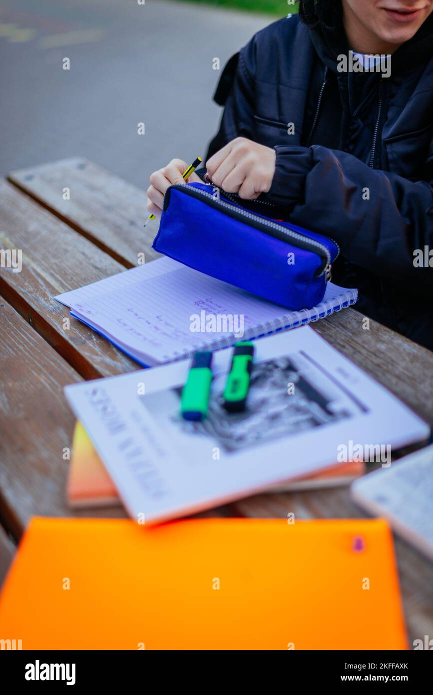 A female student is about to open her pencil case and grab a pen. She ...