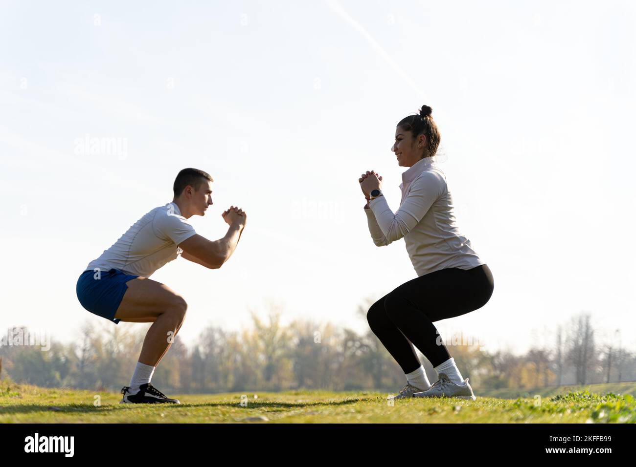 Two amazing and attractive fit friends are doing squad exercise and ...